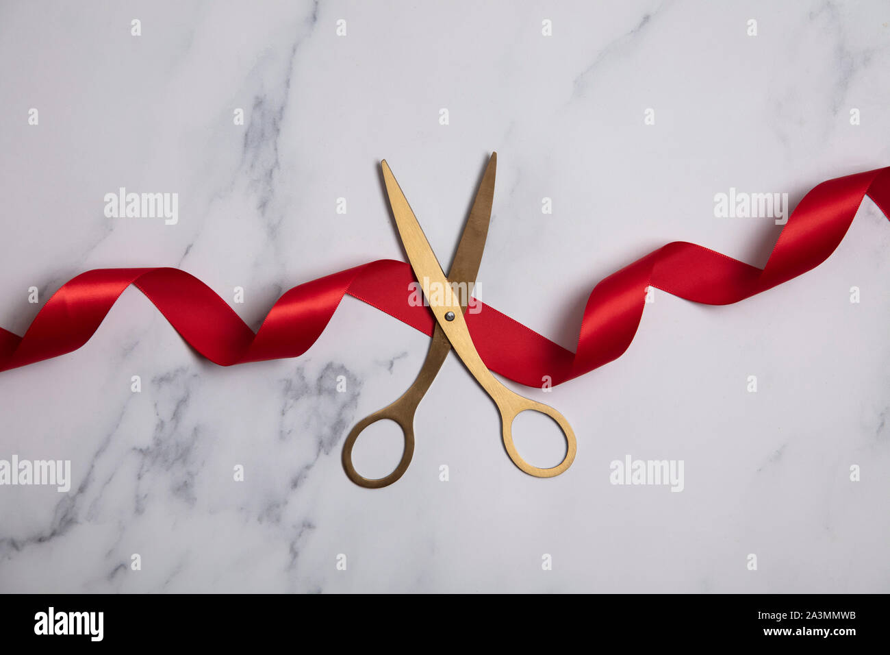Grand opening background. Gold scissors with red ribbon on a marble ...