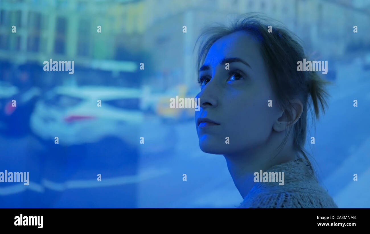 Woman looking around and watching video presentation on large display ...