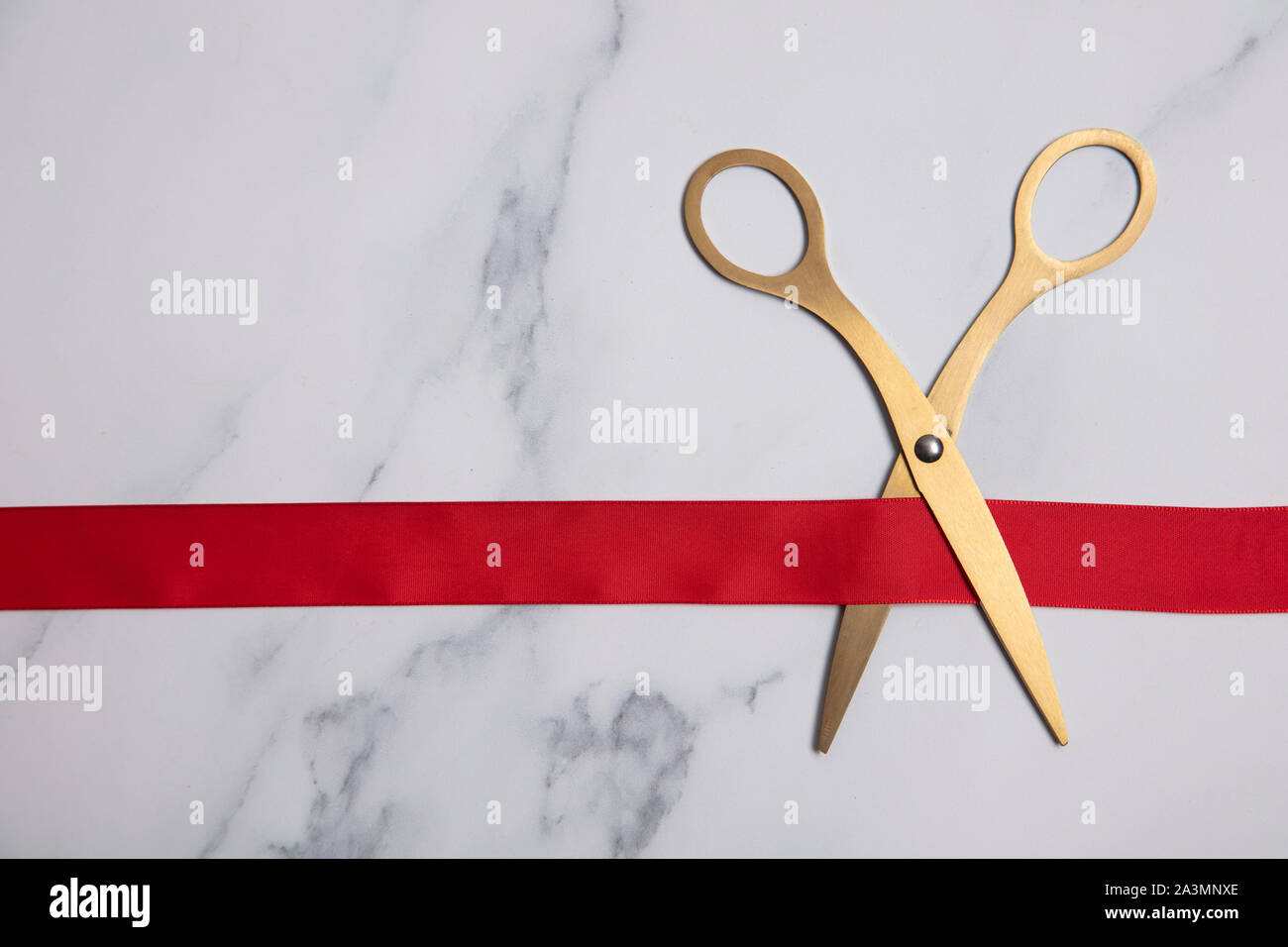 Grand opening background. Gold scissors with red ribbon on a marble ...