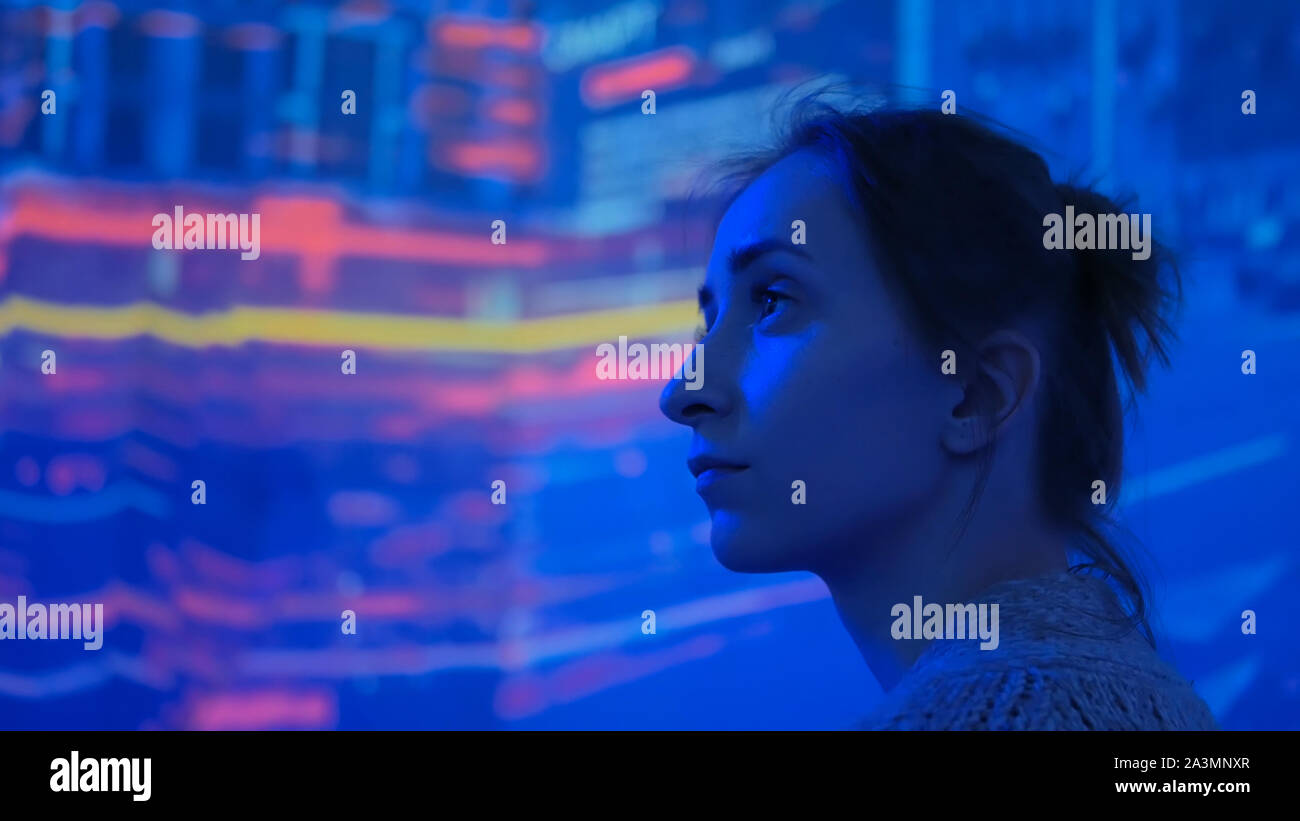 Woman looking around and watching video presentation on large display ...