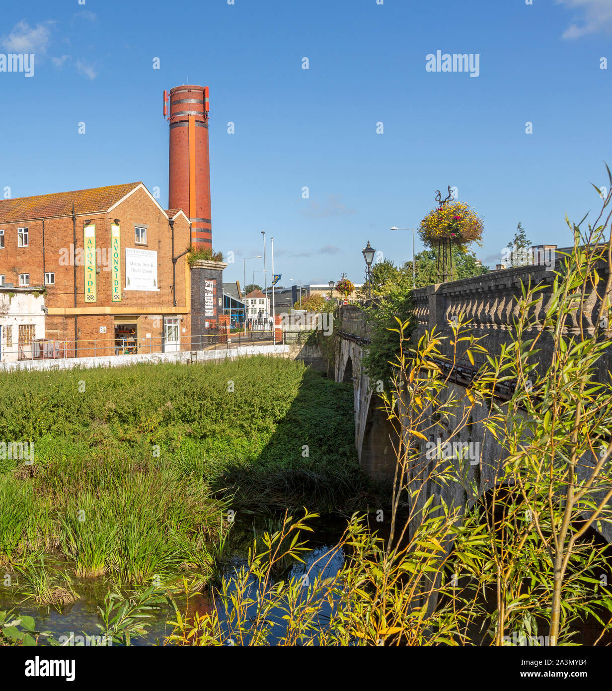 Old disused red brick industrial chimney by River Avon bridge, Melksham ...