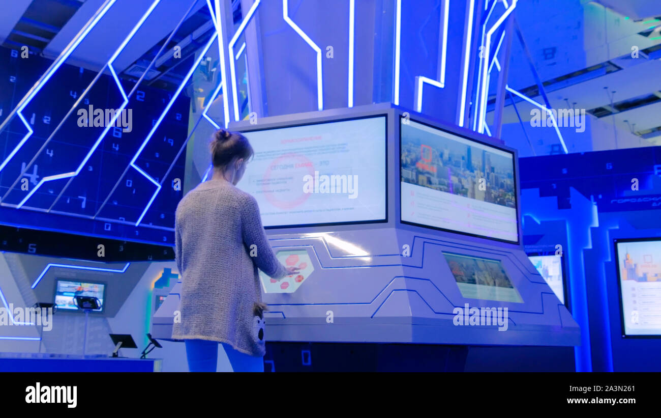 Woman using interactive touchscreen display at urban exhibition Stock ...