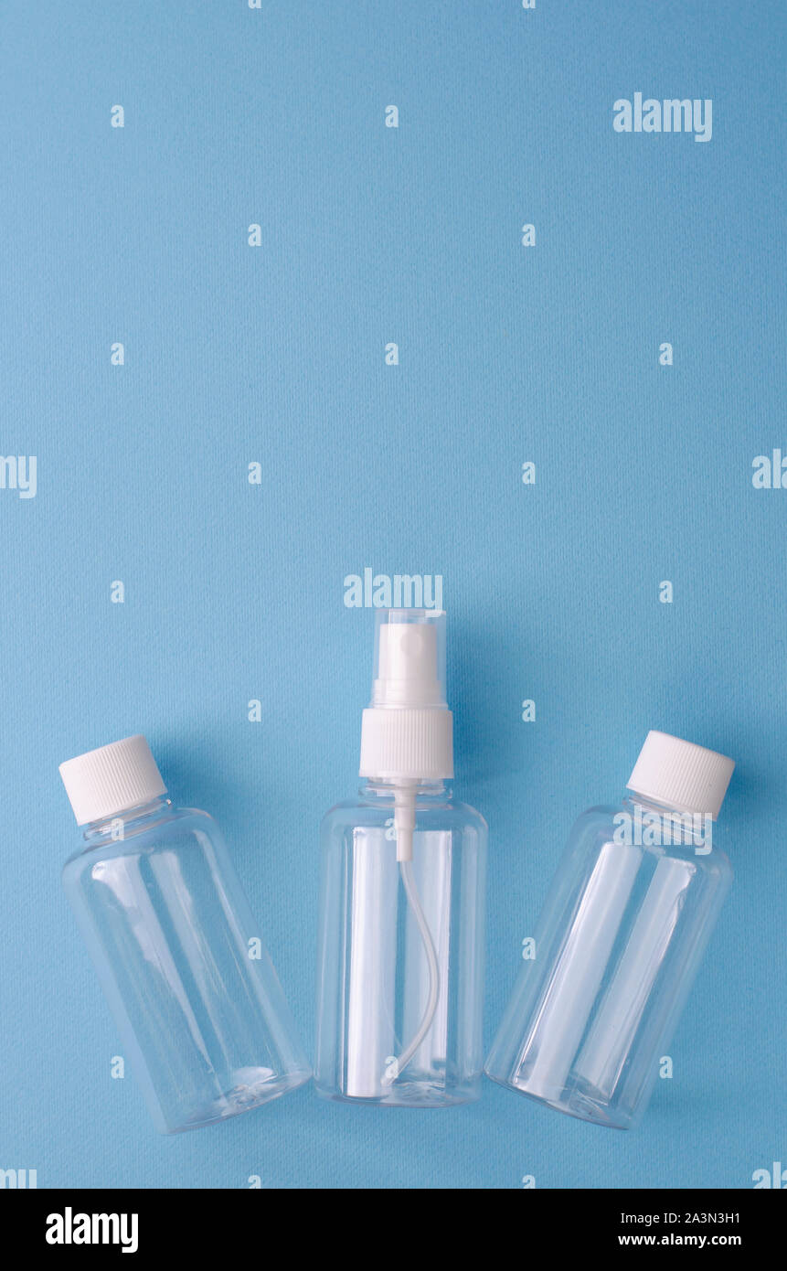 Travel set of plastic containers for beauty products on blue background ...