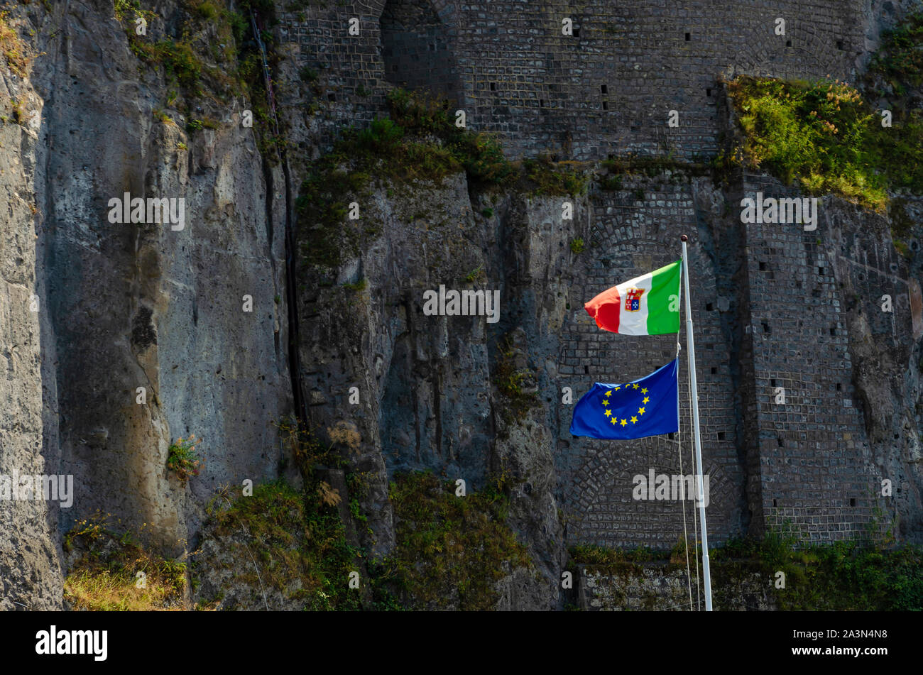 Italian and european union flags waving on an ancient brick wall ...