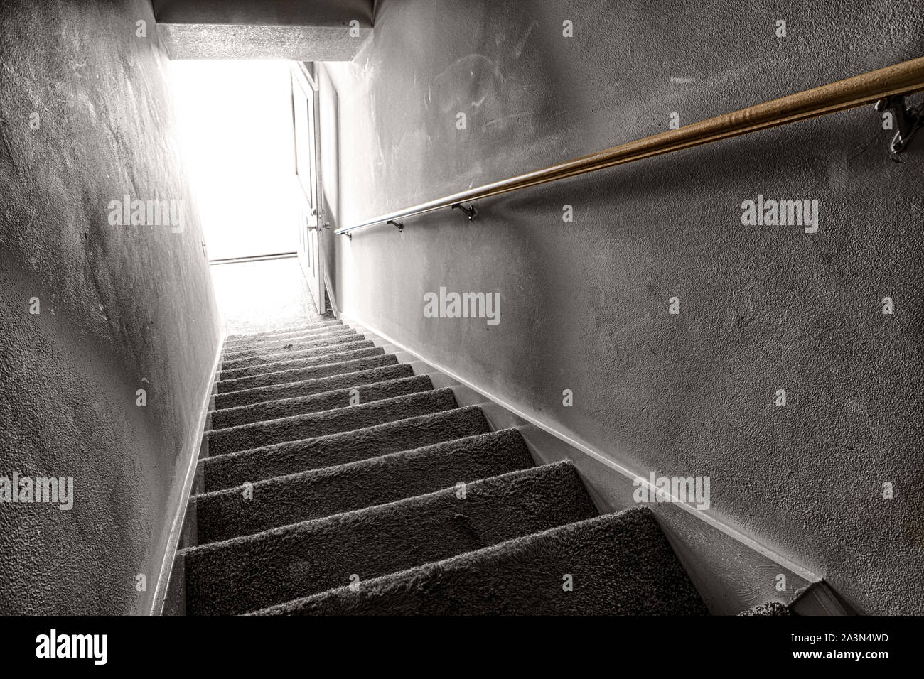 Horizontal shot looking down a stairway to the light coming from an ...