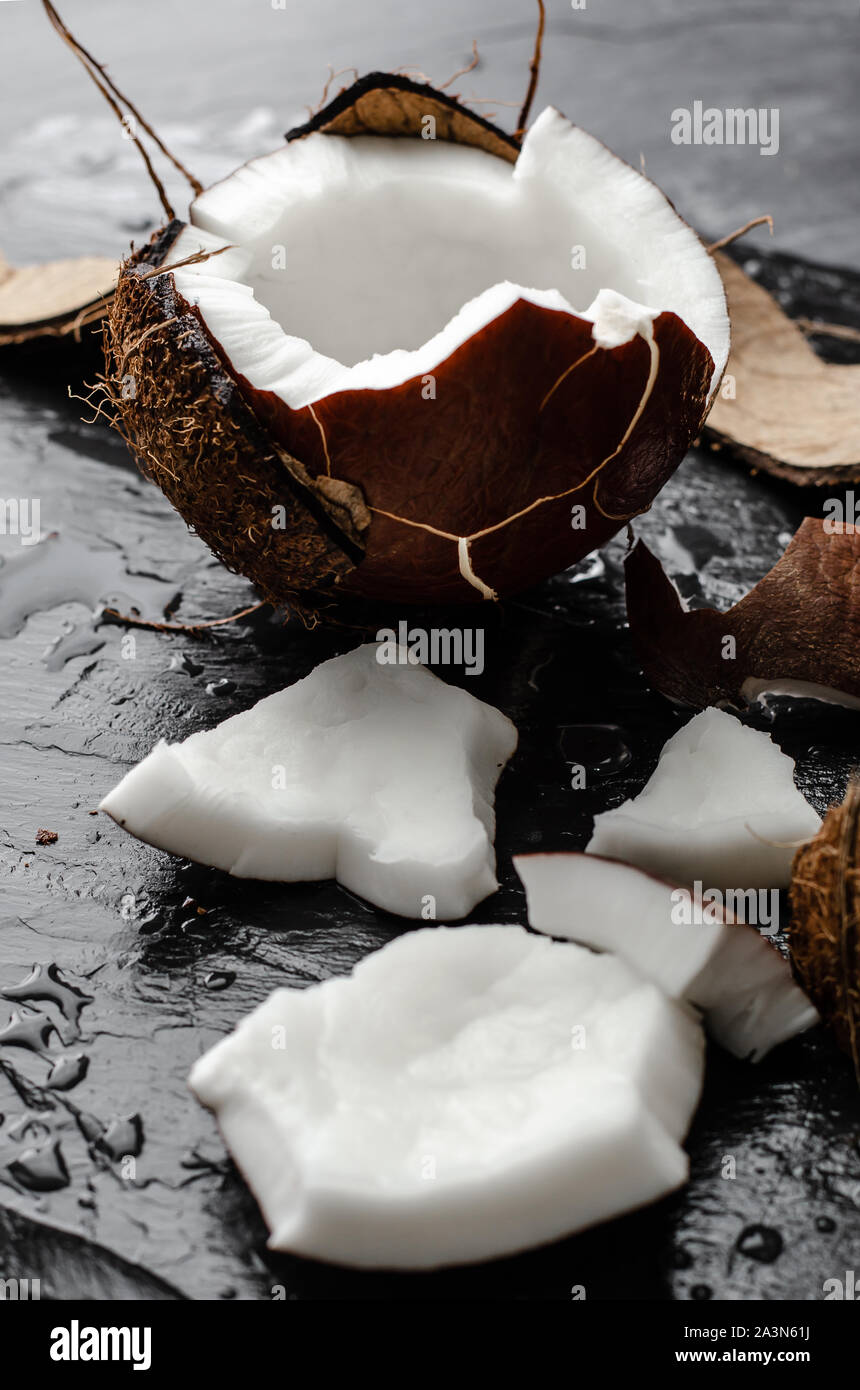 Coconut half on black slate stone background. Nutrition concept ...