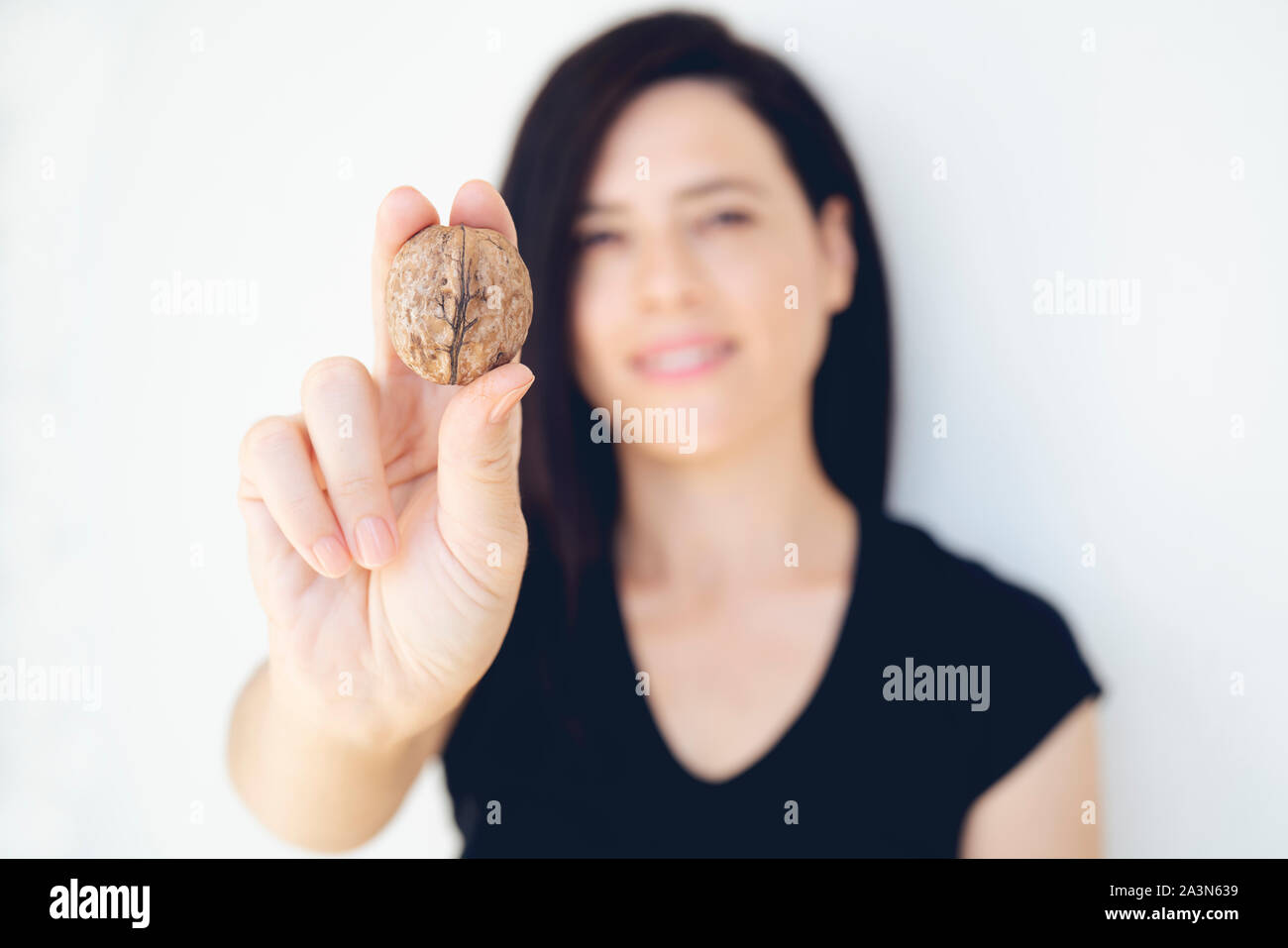 Woman holding whole walnut in her fingers. Walnuts isolated. Nut on ...
