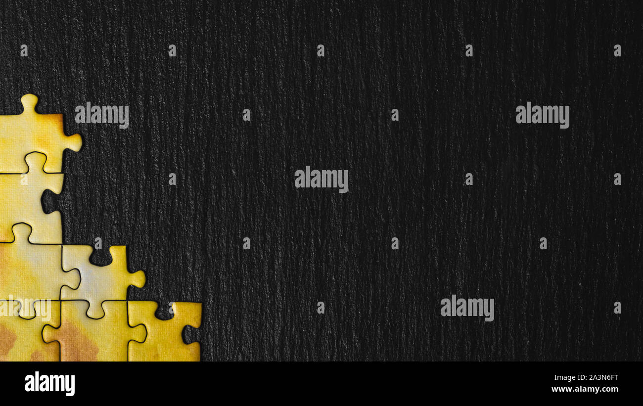 Yellow puzzle on a black stone background. Frame from puzzle around ...