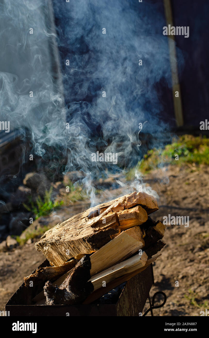 Making a bonfire for BBQ. Firewood and smoke Stock Photo - Alamy