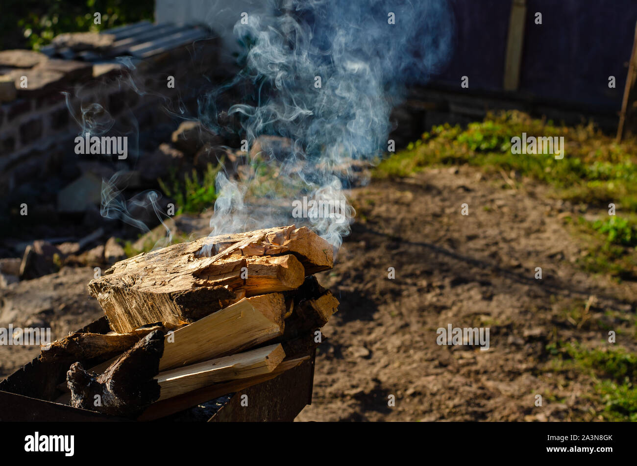 Making a bonfire for BBQ. Firewood and smoke Stock Photo - Alamy