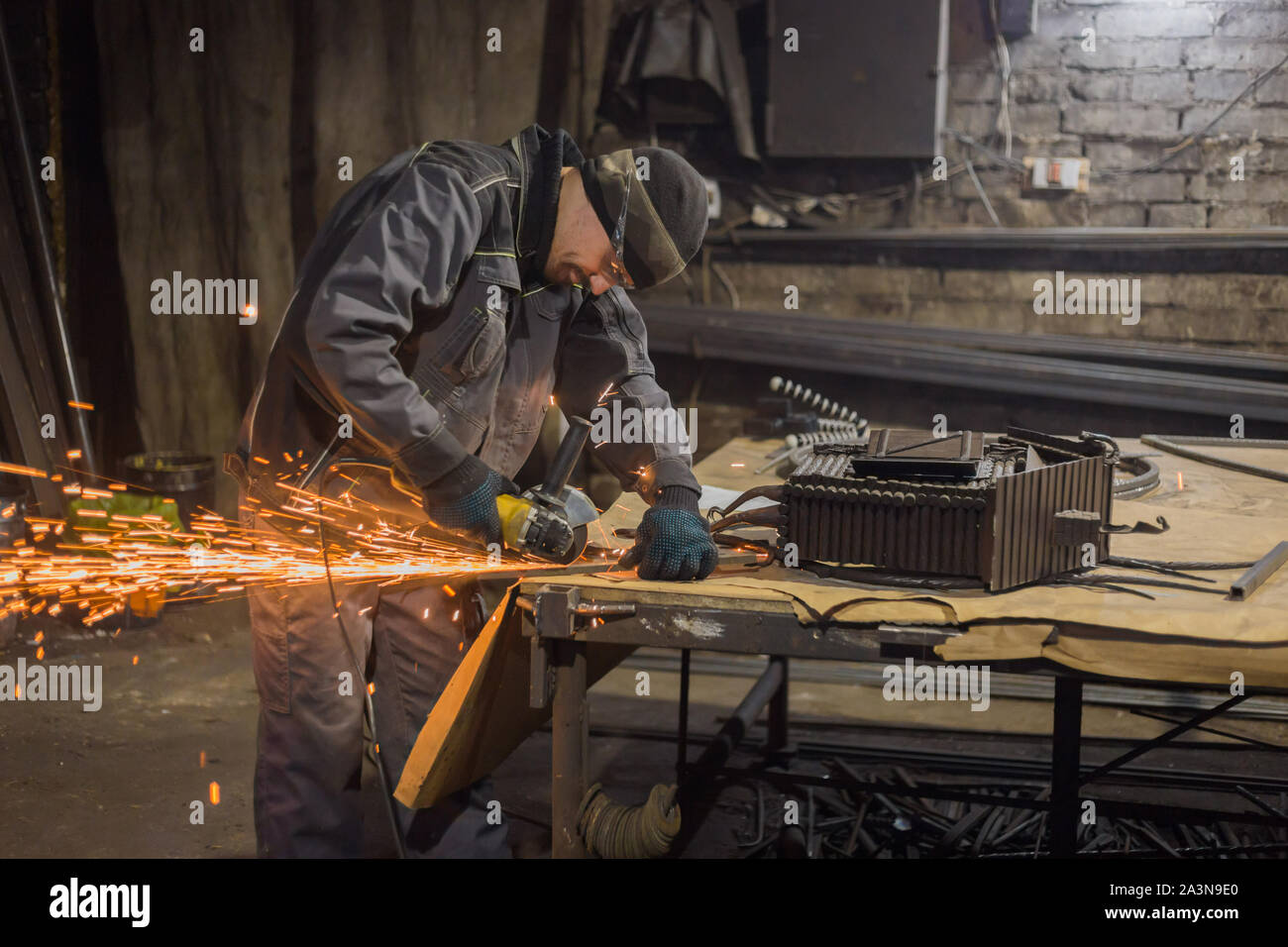 Blacksmith sawing metal with hand circular saw Stock Photo - Alamy