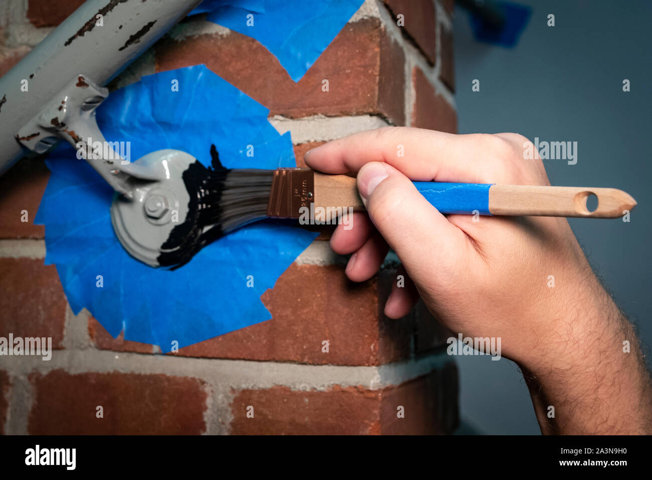 Hand painting metal hand railing on brick wall - prepped with painter's ...