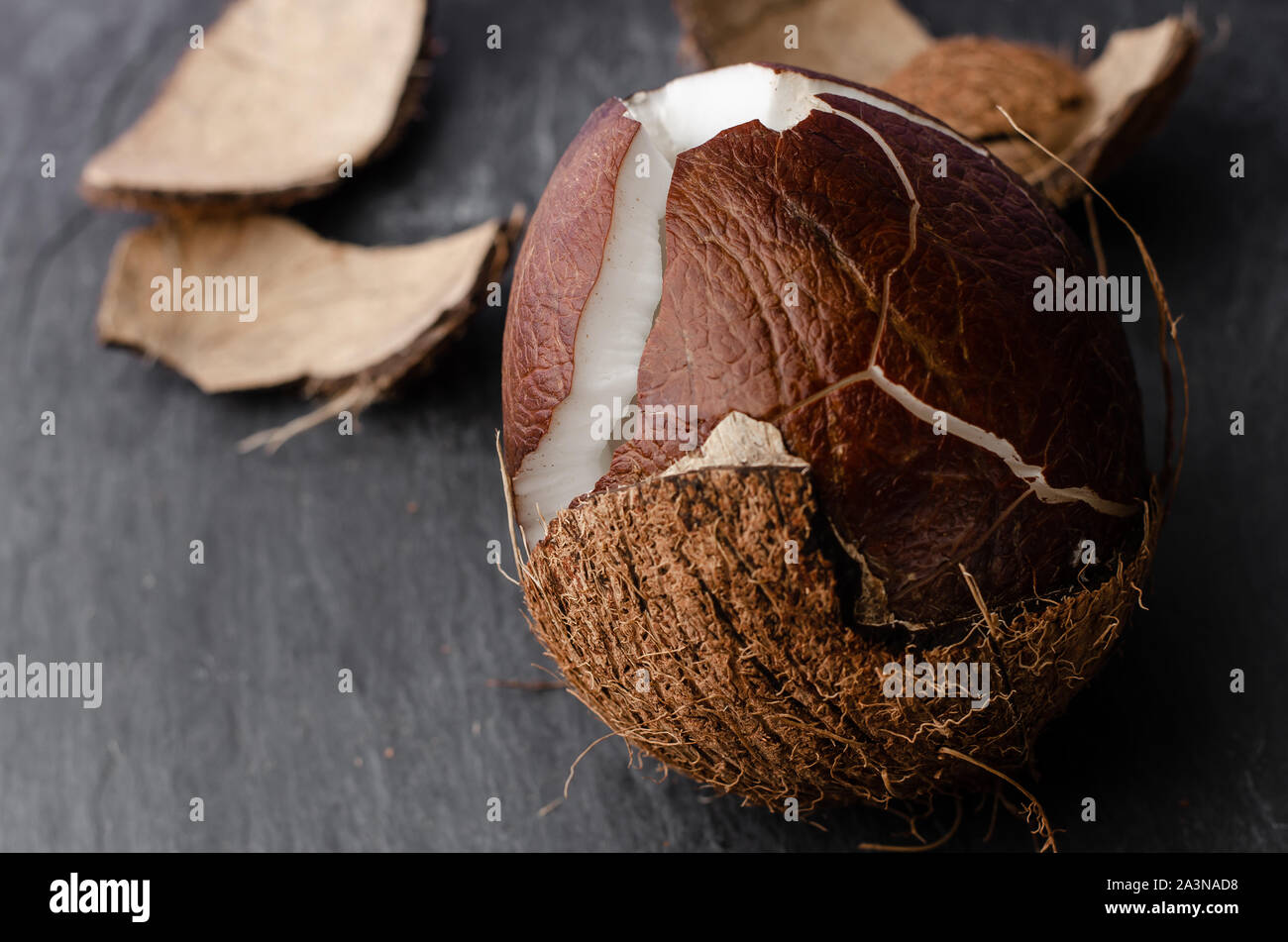 Cracked coconut on dark stone background. Exotic food concept Stock ...