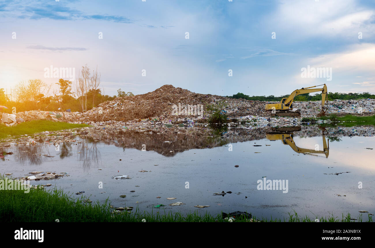 A yellow backhoe is lifting garbage at waste separation plant, Mountain ...