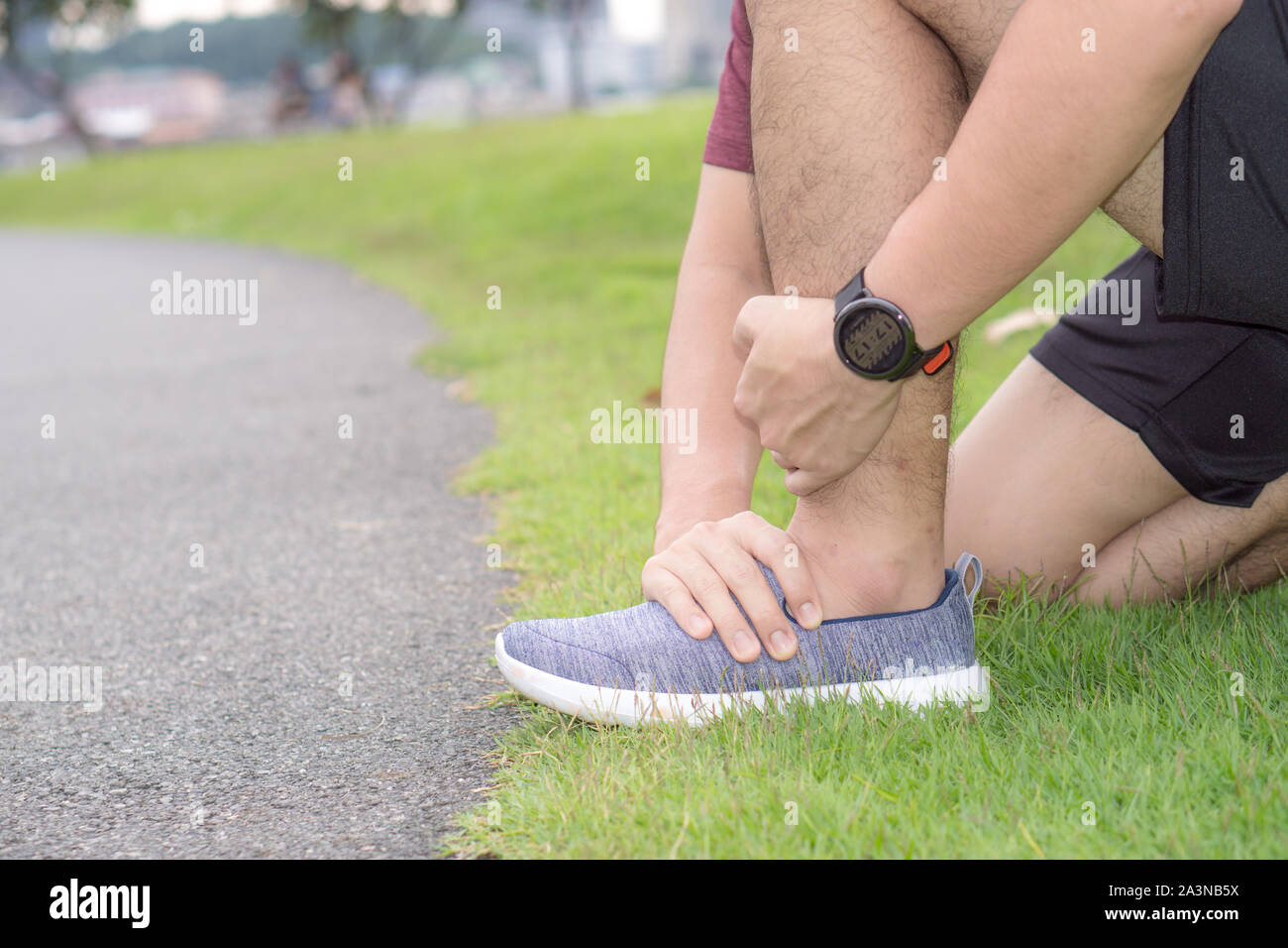 Ankle sprained. Young man suffering from an ankle injury while running ...