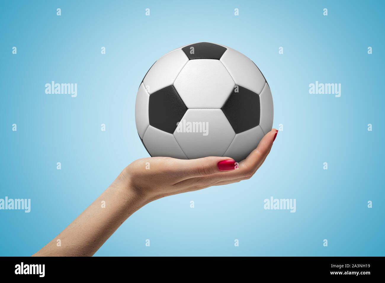 Side closeup of woman's hand facing up and holding new football on ...