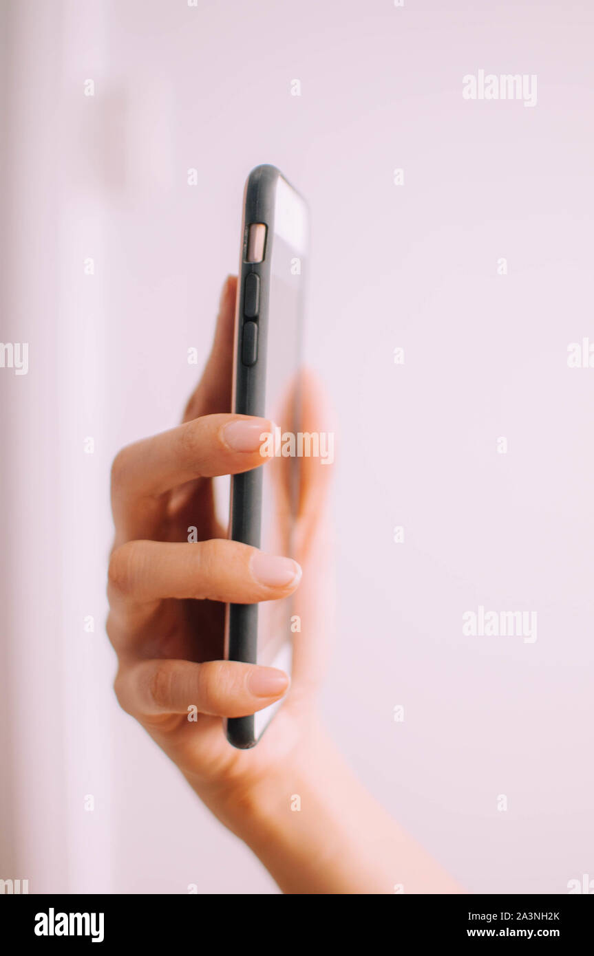 A close-up view of a young person's hand using a mobile phone on a ...