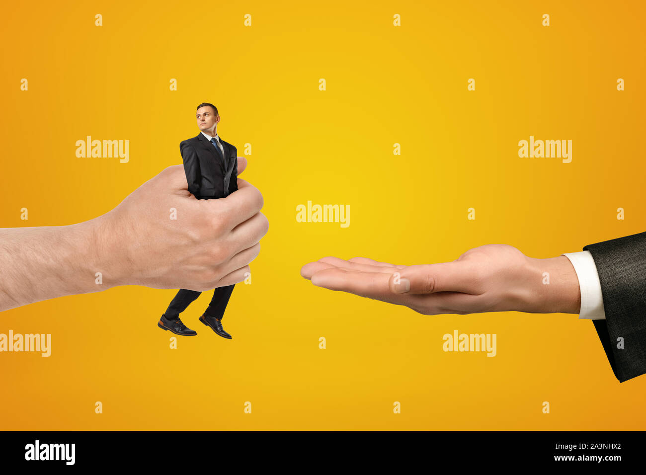 Big male hand passing tiny businessman to another hand on yellow ...