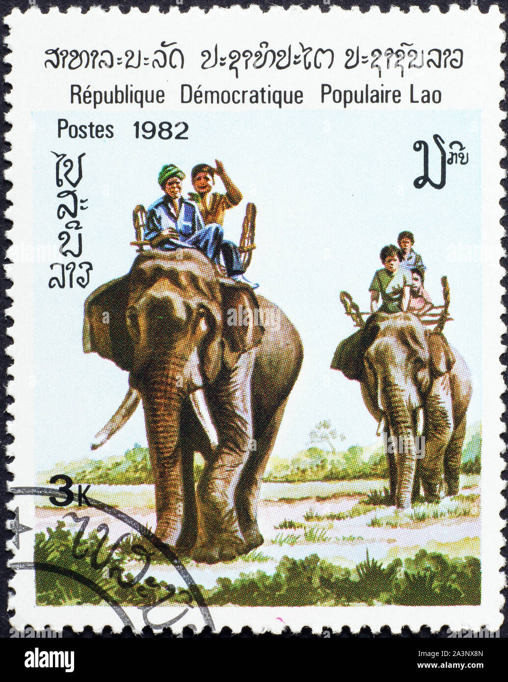 People riding elephants on postage stamp of Laos Stock Photo - Alamy