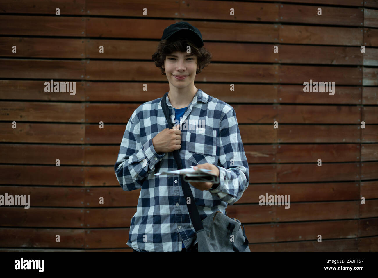 young postman deliver the newspaper envelope and documents at homes ...