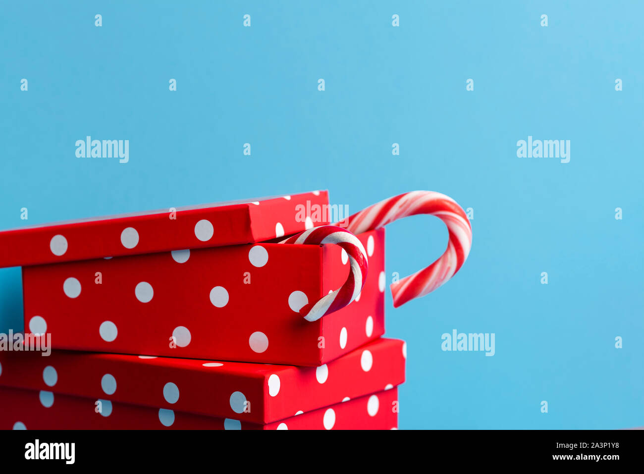 Red gift boxes with white spots and candy canes, on a blue background ...