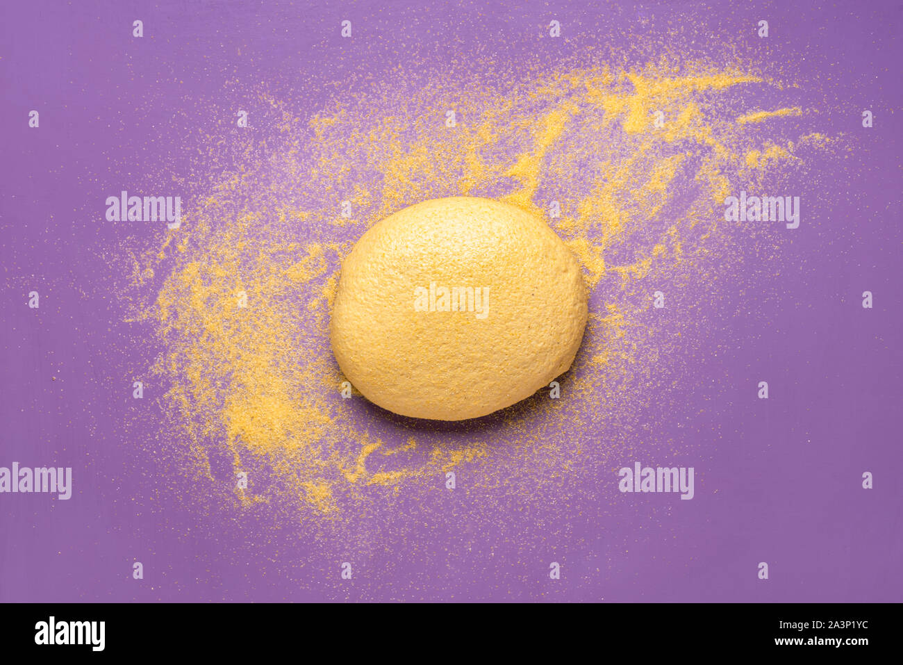 Yellow dough made of corn flour for cornbread on a purple background ...