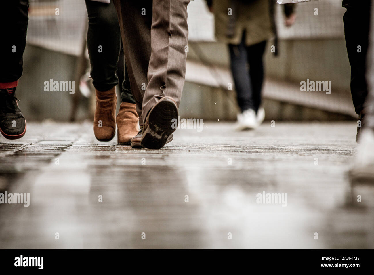 Walking on the wet surface. People walking at rainy day Stock Photo - Alamy