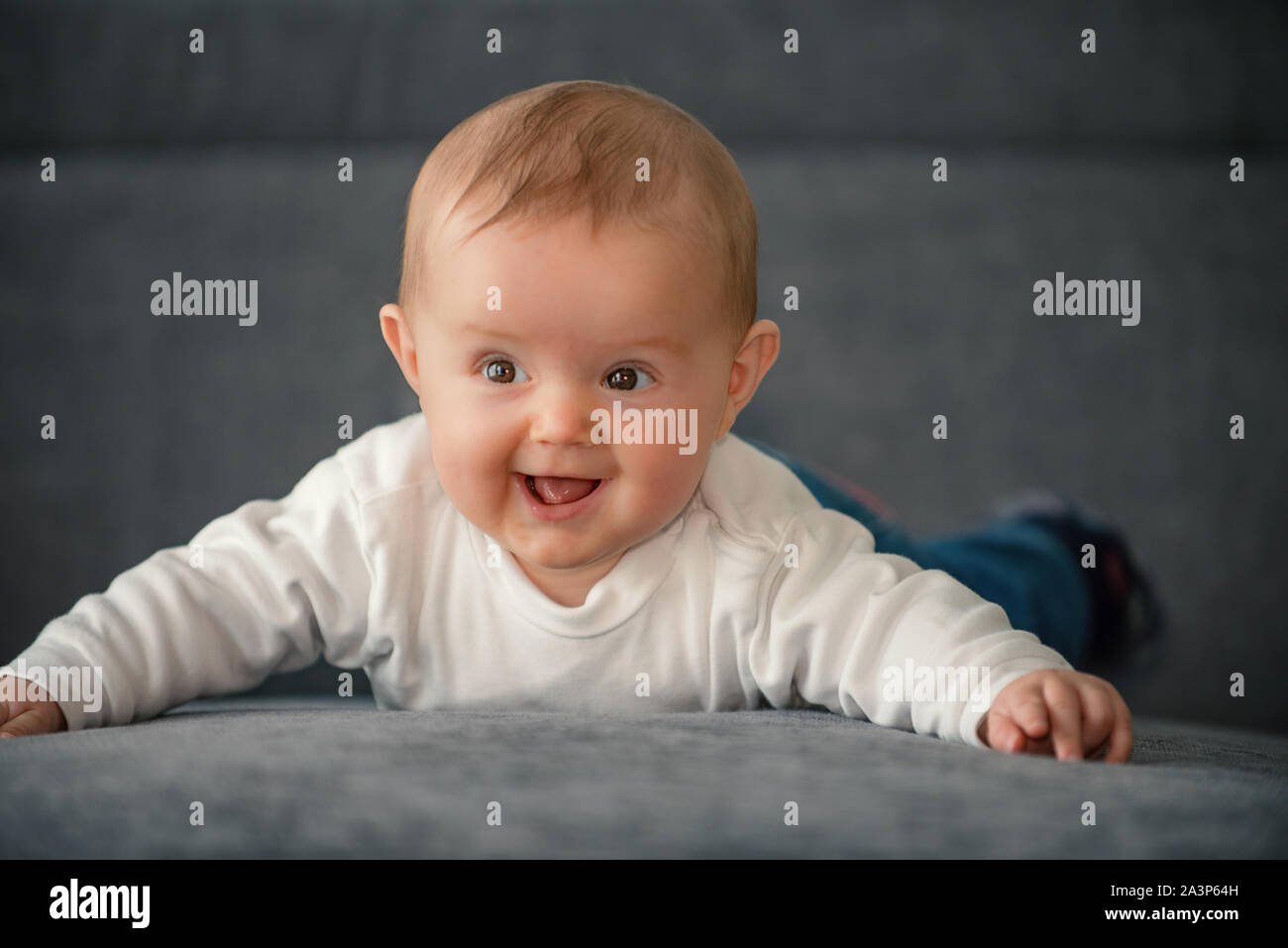 Little laying baby girl smiling and having fun Stock Photo - Alamy