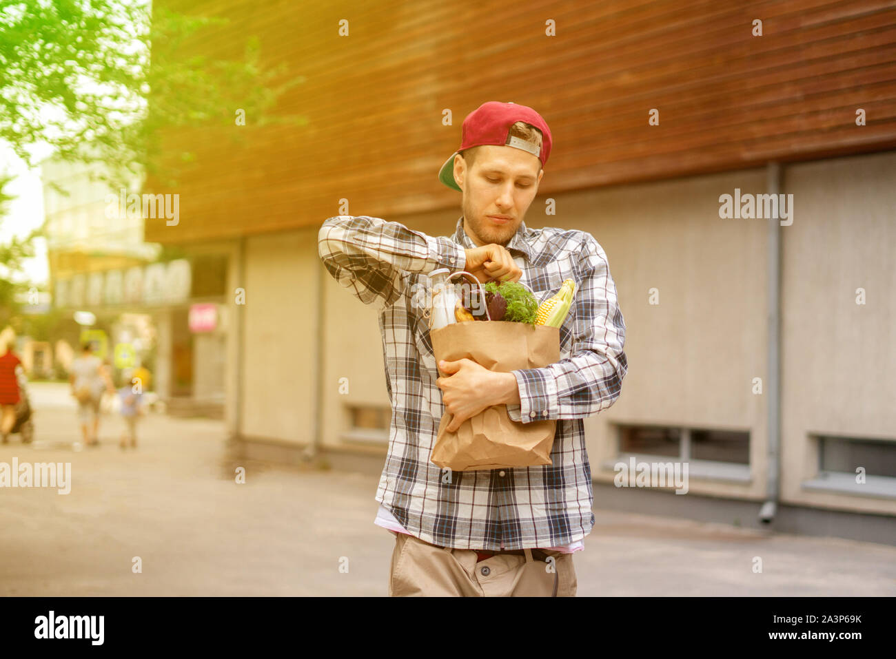 young man going home from the grocery store with fresh fruit and ...