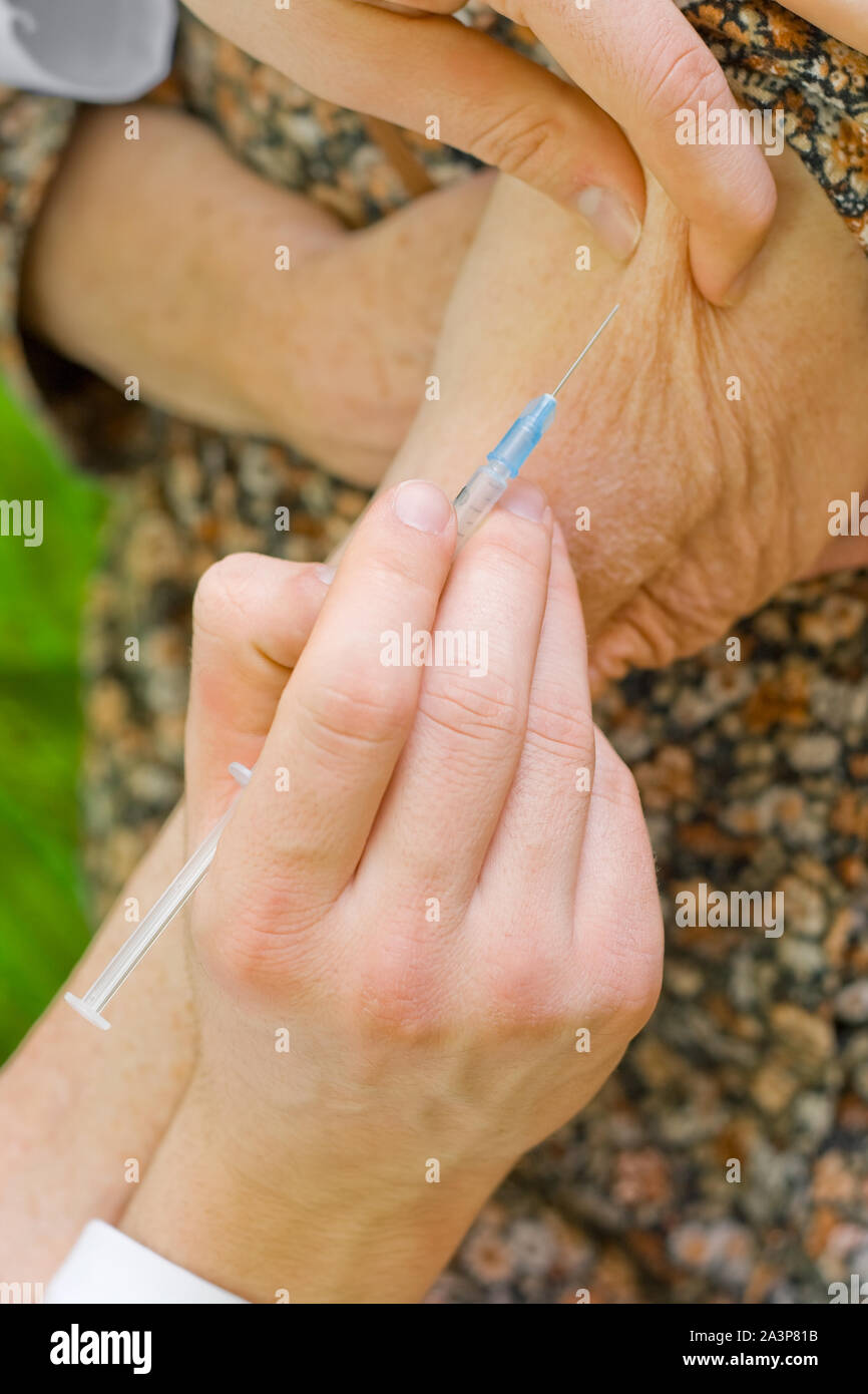 The doctor gives old woman's hypodermic injection Stock Photo - Alamy