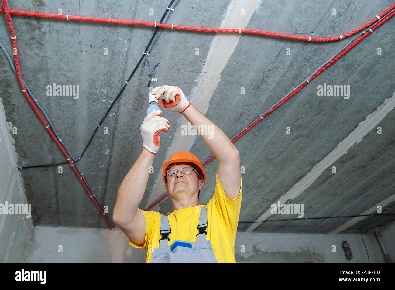 The electrician is setting a light bulb for temporary lighting Stock ...