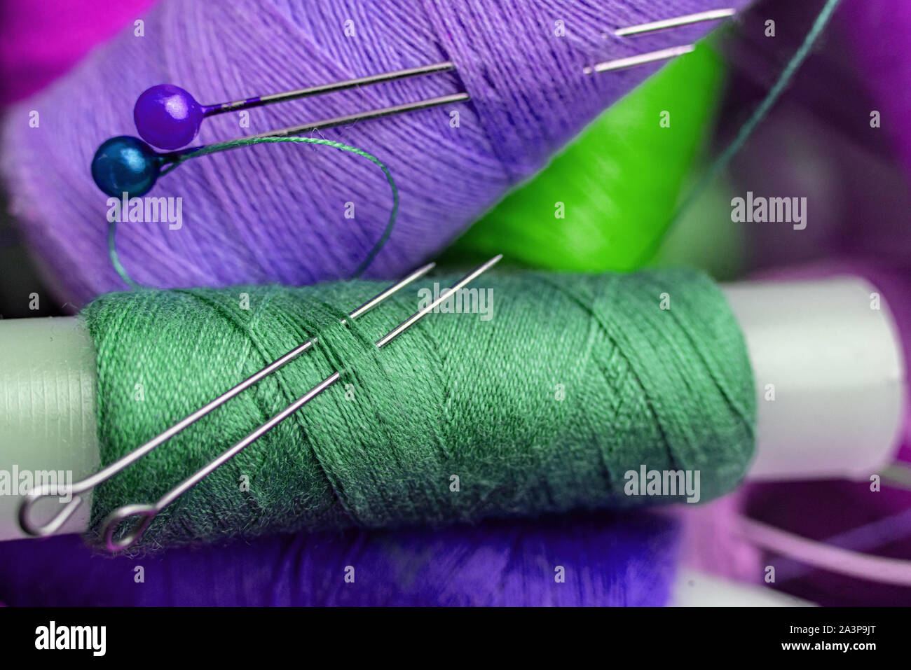 macro shot of needle inserted in the color thread rolls Stock Photo - Alamy