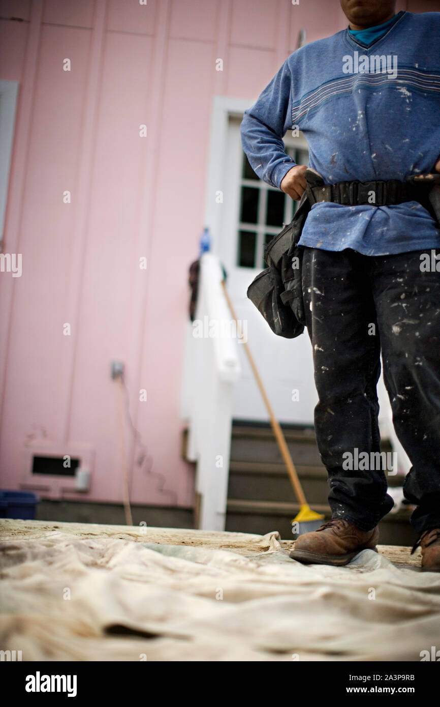 Construction worker wearing a tool belt and work clothes Stock Photo ...