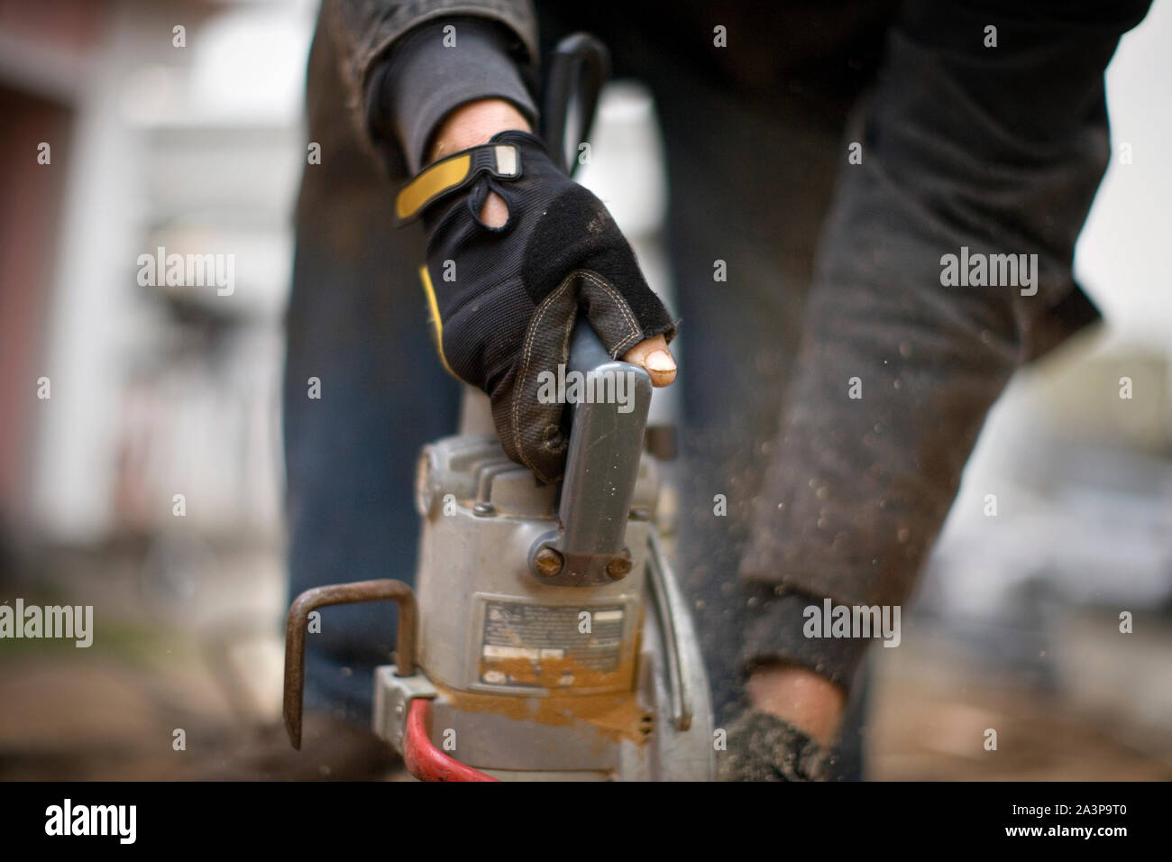 Gloved hands holding a work tool Stock Photo - Alamy