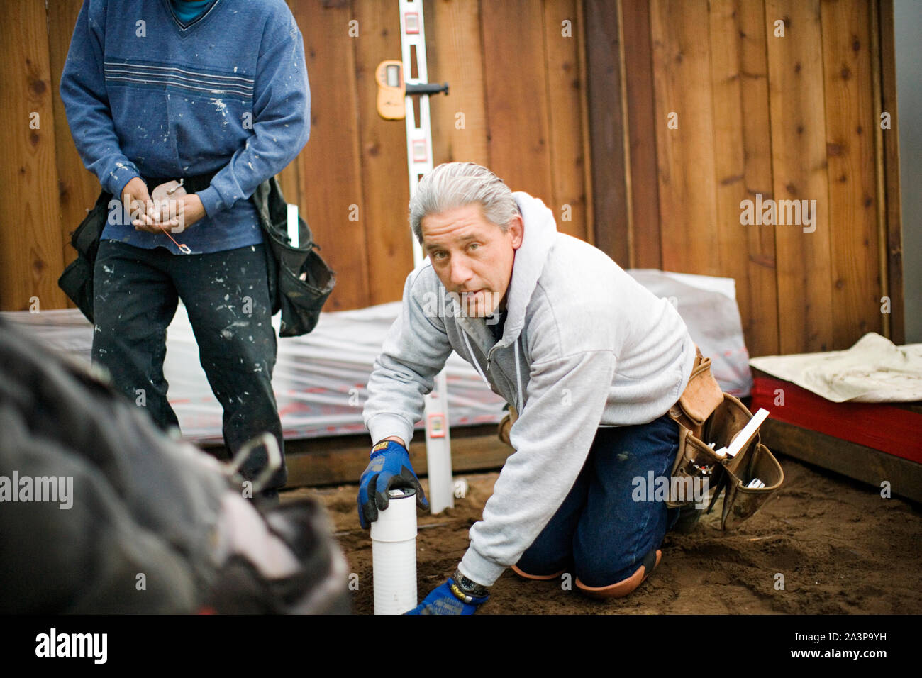 Portrait of a mature construction worker kneeling Stock Photo - Alamy