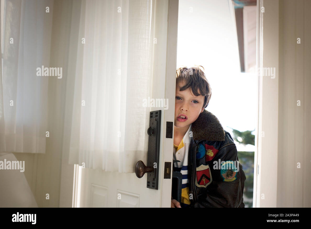 Boy arriving home through the front door Stock Photo - Alamy