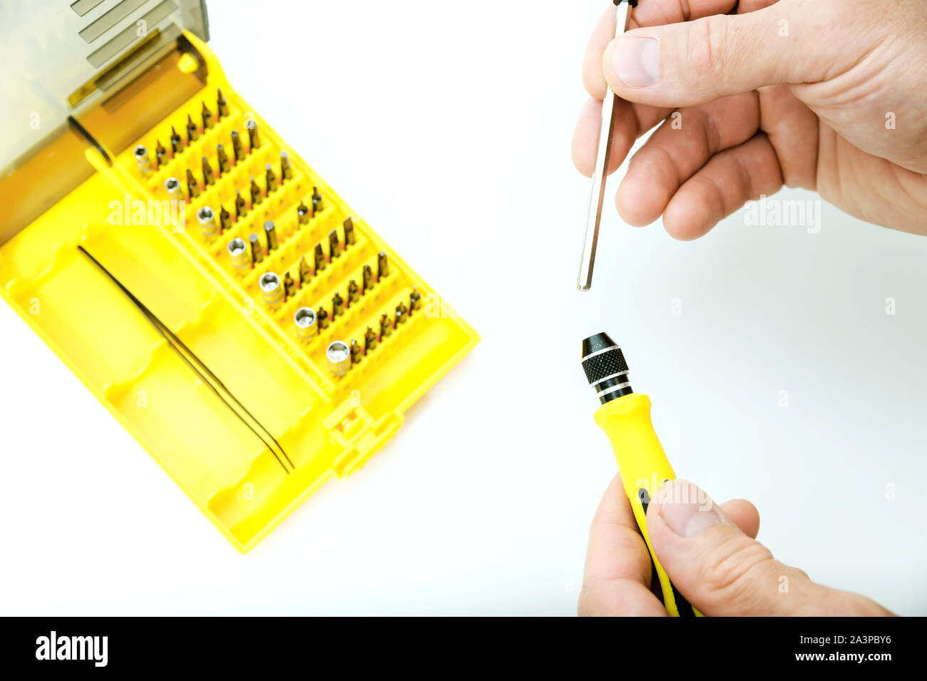 Man's hands is holding parts of a collapsible screwdriver. In the ...