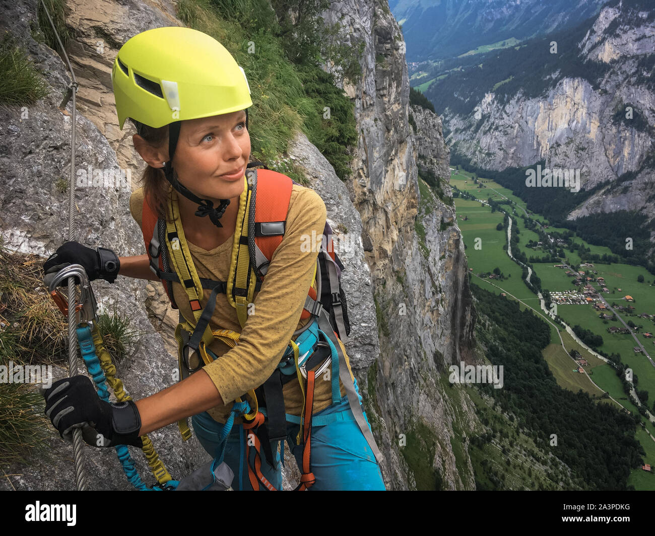 Pretty, female climber on a via ferrata - climbing on a rock in Swiss ...