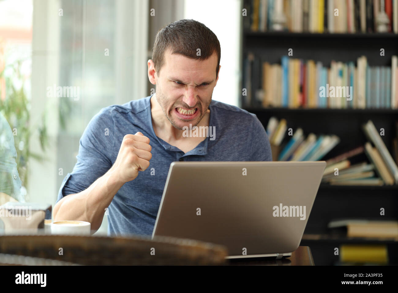 Angry adult man checking laptop online content sitting in a bar or home ...