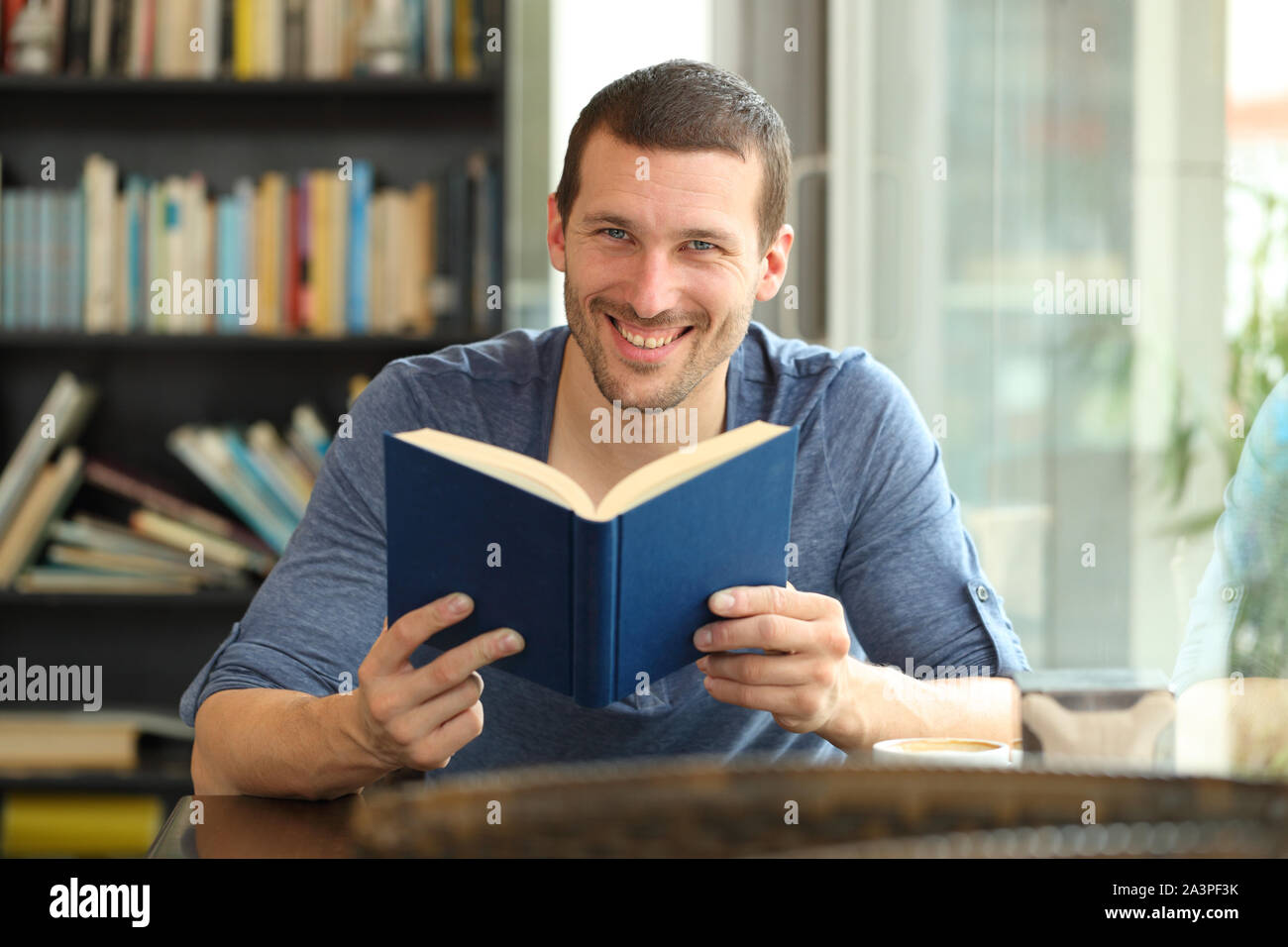 Student man holding book library smiling happy hi-res stock photography ...