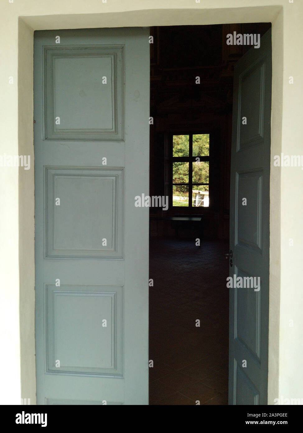open blue door that shows the landscape beyond the window in a dark ...