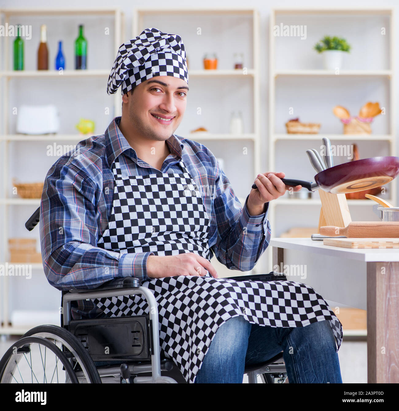 The disabled young husband frying at kitchen Stock Photo - Alamy