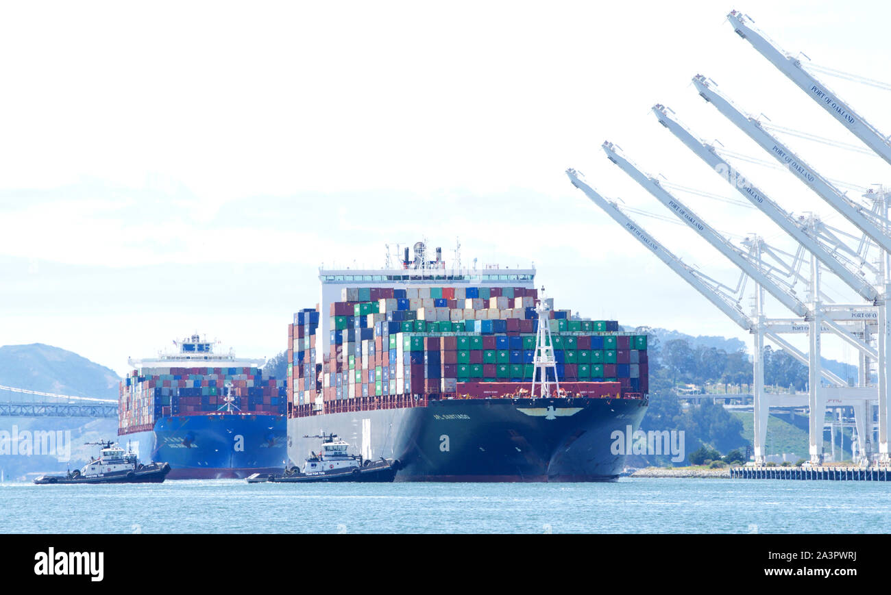 Oakland, CA - May 07, 2019: Multiple tugboats assisting Cargo Ships APL SANTIAGO and CSCL BOHAI ...