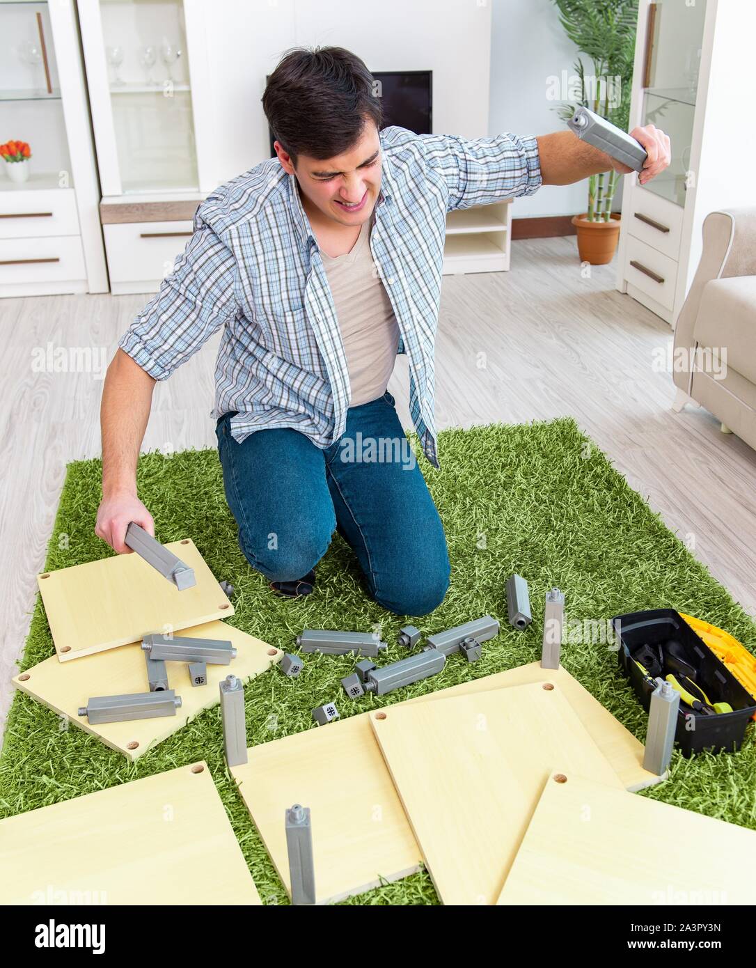 The man assembling furniture at home Stock Photo - Alamy