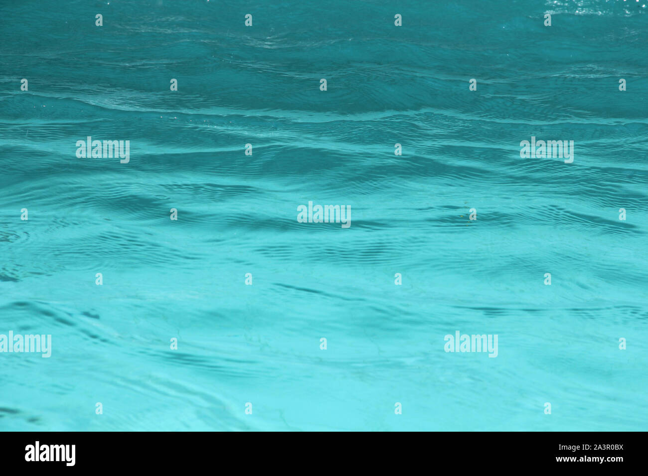 Blue pool water reflecting sun rippled details.surface of blue pool ...