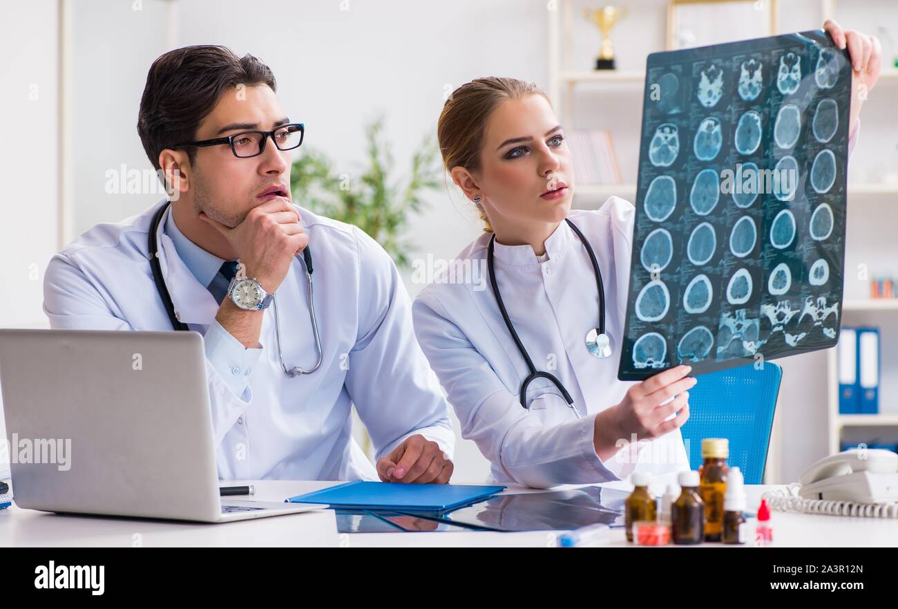 Two doctors examining x-ray images of patient for diagnosis Stock Photo ...