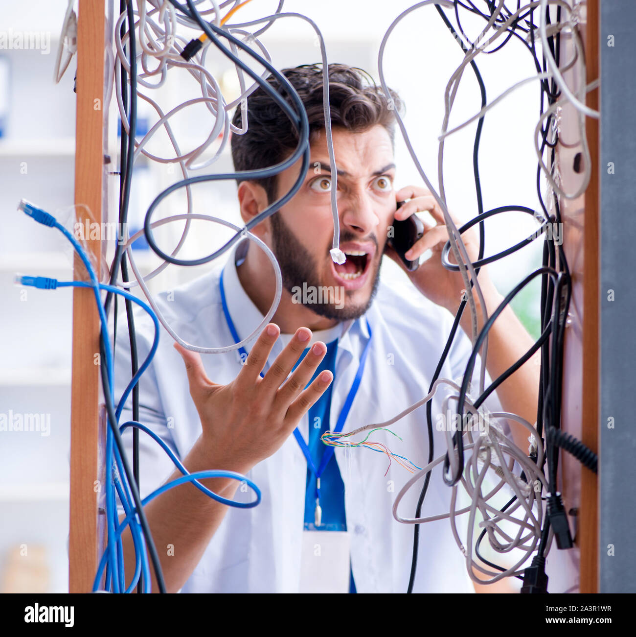 The electrician trying to untangle wires in repair concept Stock Photo ...