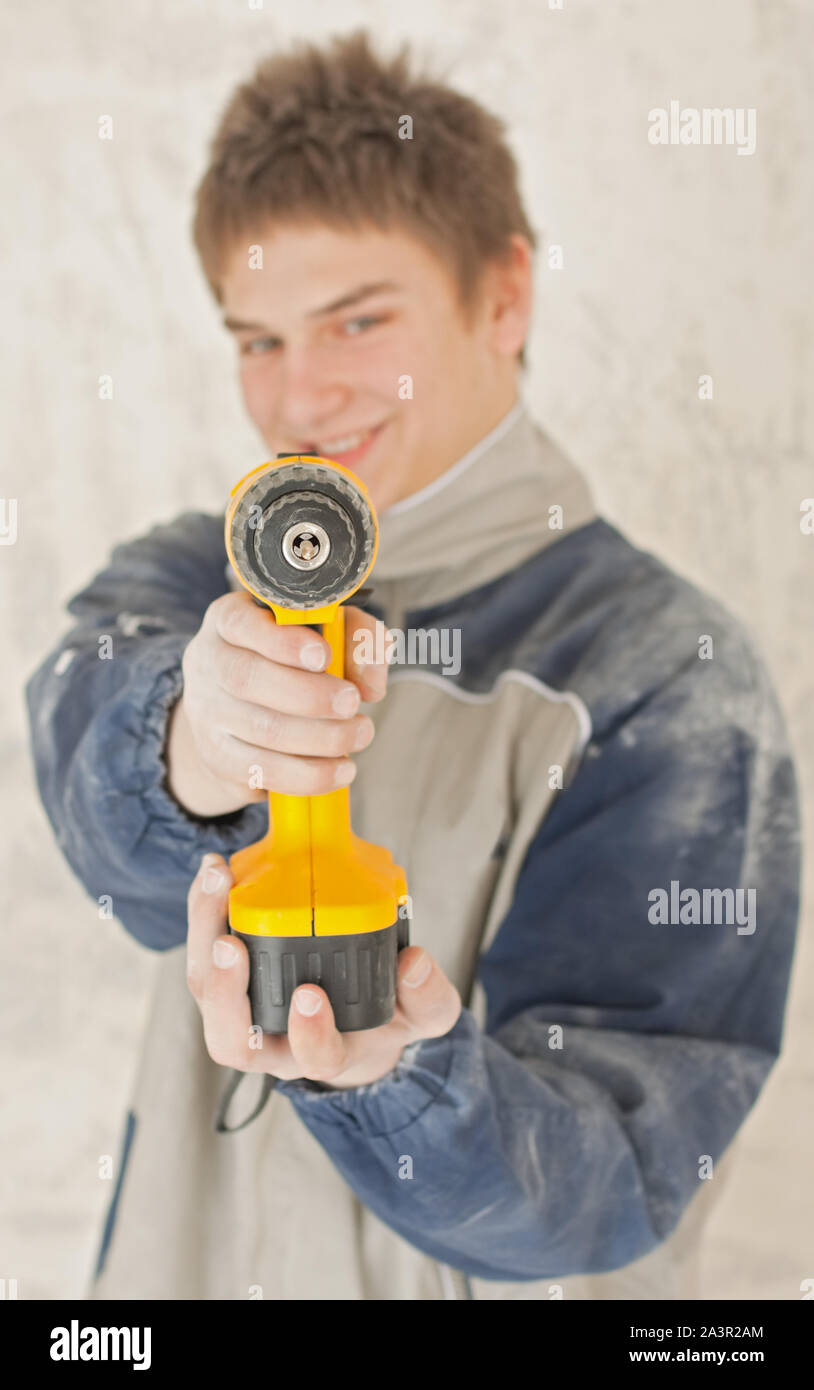 Young smiling builder in the construction making something Stock Photo ...