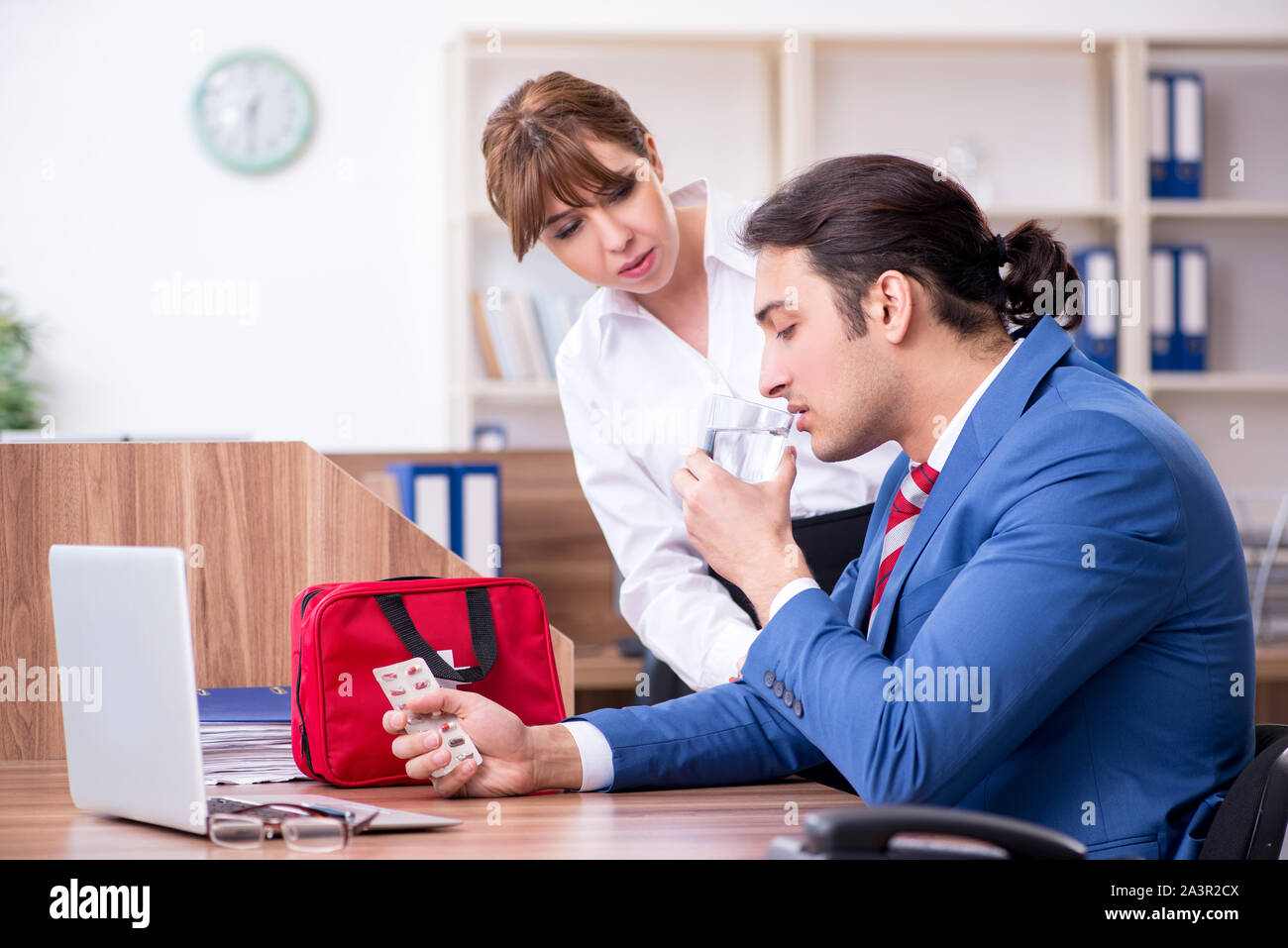 Employee receiving first aid in office Stock Photo - Alamy