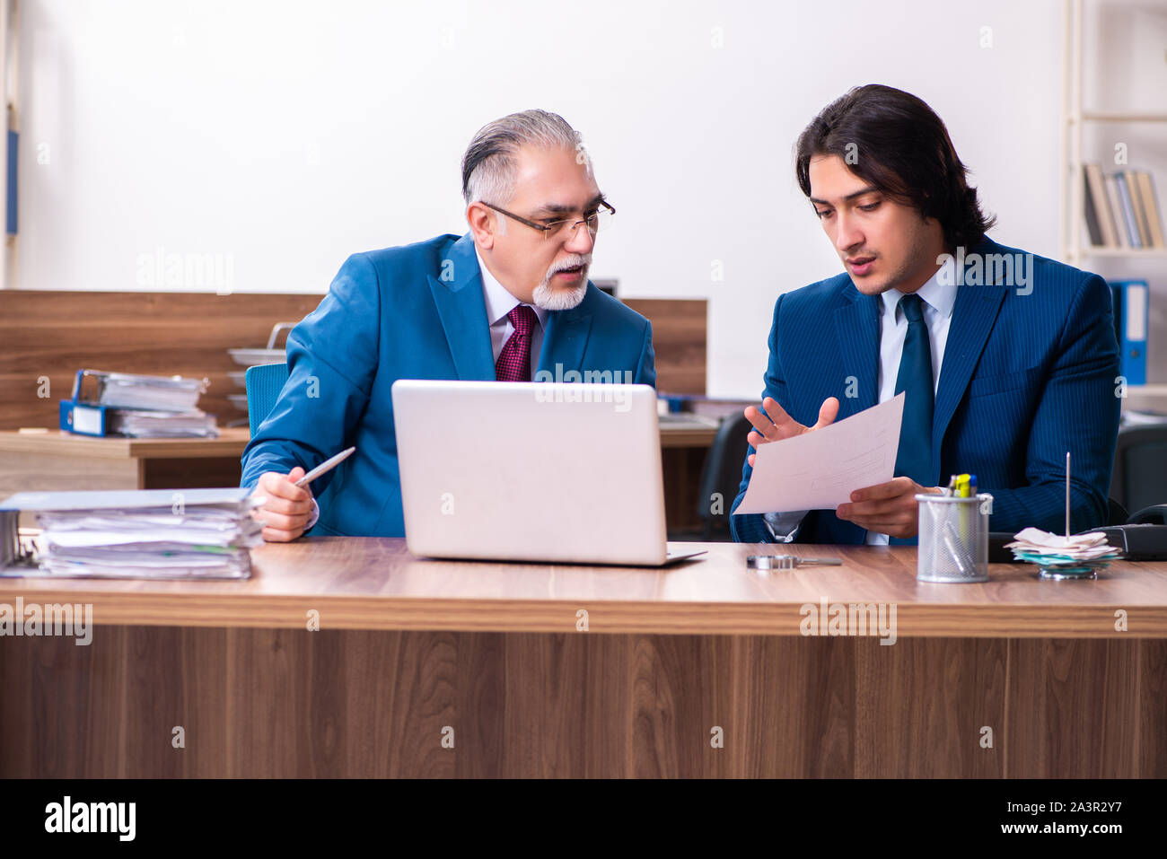 The young and old employees working together in the office Stock Photo ...